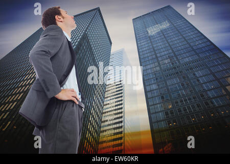 Composite image of stern businessman standing on ladder Stock Photo - Alamy