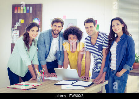 Group of young colleagues using laptop Stock Photo - Alamy