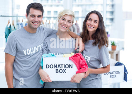 Volunteers friends holding a donation box Stock Photo - Alamy
