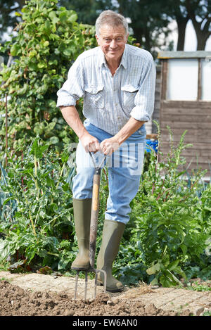 Senior Man Digging Vegetable Patch On Allotment Stock Photo - Alamy