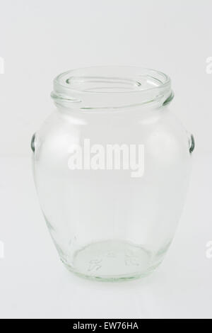 A clear glass jar without a lid full of dried chillies on an acacia ...