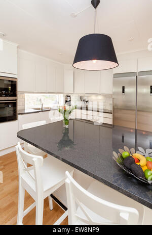 Modern white kitchen with gray island and drop down ceiling island ...