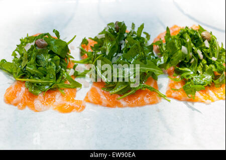 fresh salmon carpaccio sushi sashimi with arugula rocket salad and ...