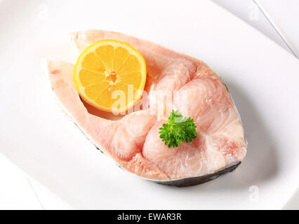 Raw steak of carp fish with lemon and thyme on white wooden background ...