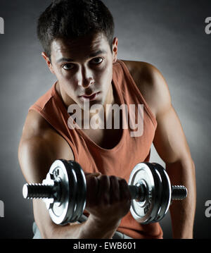 Athletic man working with heavy dumbbell, geometric pattern Stock Photo ...