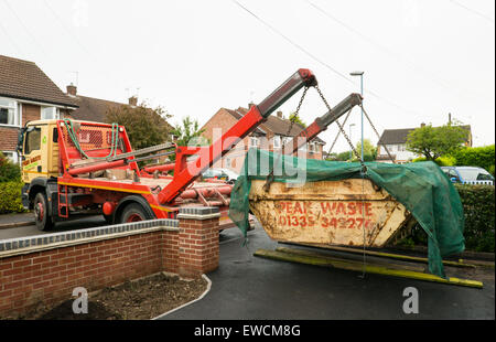 A large skip dumpster truck lorry unloading waste at a recycling Stock ...