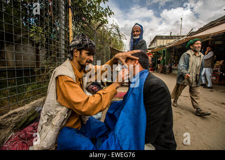 Barber shaves client on Bazaar street in Old city of Kabul, Afghanistan ...
