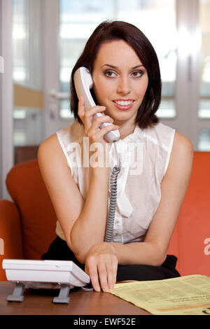 Businesswoman conversing on landline phone, portrait Stock Photo - Alamy