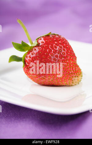 Cut juicy strawberry on the plate isolated Stock Photo - Alamy