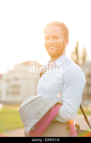 Happy handsome man is standing on minimalistic kitchen and smiling ...