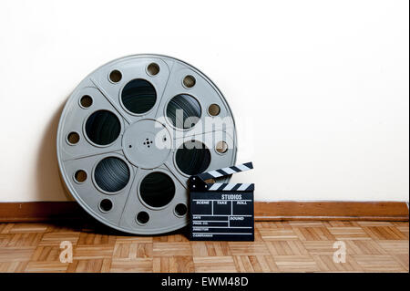 35 mm cinema movie roll and reels with clapper and filmstrip on wooden ...
