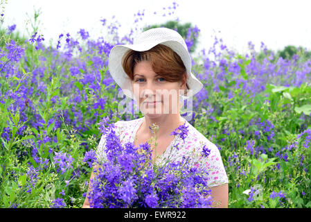 WoWoman with a bouquet of wild flowers on the lawnman with a bouquet of ...