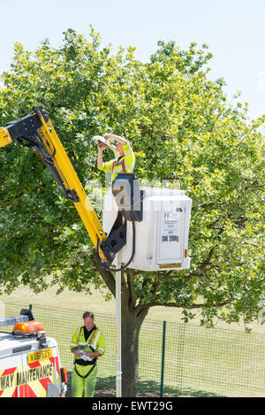 Cherry picker being used for traffic light maintenance in suburban ...