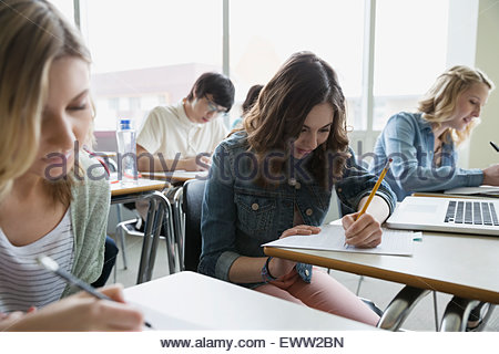 Students taking exam in classroom. Education test and literacy concept ...