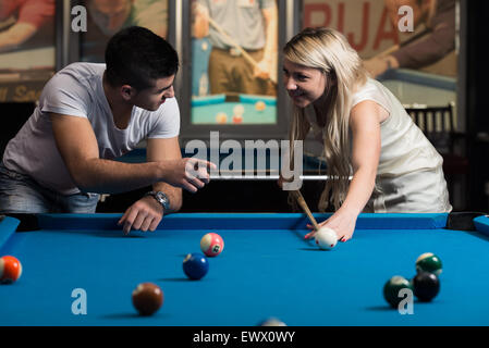 Man teaching woman how to play pool Stock Photo - Alamy