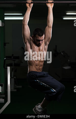 Young Man Performing Hanging Leg Raises Exercise - One Of The Most ...