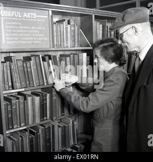 Historical, 1950s, young female librarian at counter in a library about ...