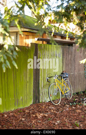 Bicycle leaning against a fence Stock Photo - Alamy
