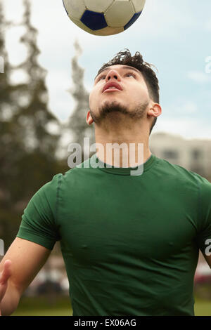 Young man heading a soccer ball Stock Photo - Alamy