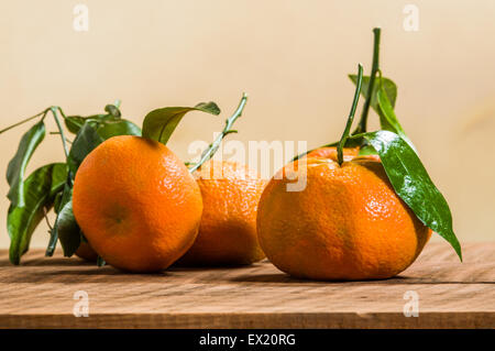 Ripe tangelos with green leaves on a wooden table Stock Photo - Alamy