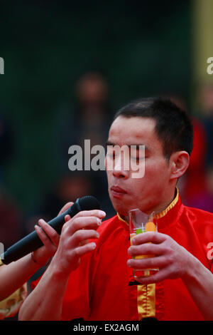 A stunt performer performs eating glass cup for visitors to welcome the ...