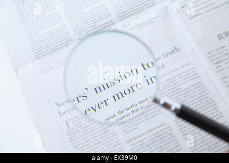 Newspaper and magnifying glass Stock Photo - Alamy