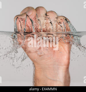 Fist punching up through water Stock Photo - Alamy
