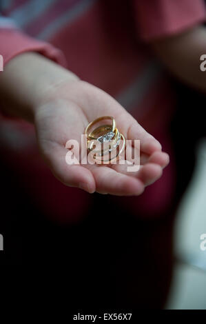 A child's hand holding wedding rings Stock Photo - Alamy