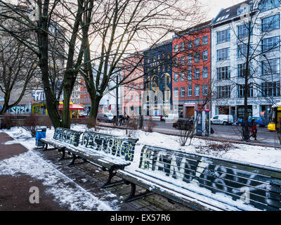 A view of the snow covered buildings and road with traffic by the city ...