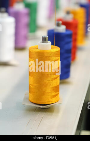 Sewing gold threads on a gold background. Bright shiny threads ...