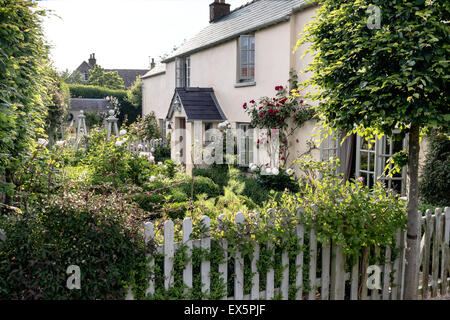 Exterior facade of an English country cottage with picket fence and ...