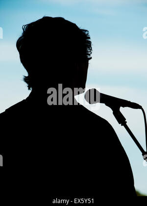 Silhouette of singing young man with microphone on white background ...