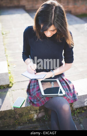 pretty woman using tablet outdoor laying on grass Stock Photo - Alamy