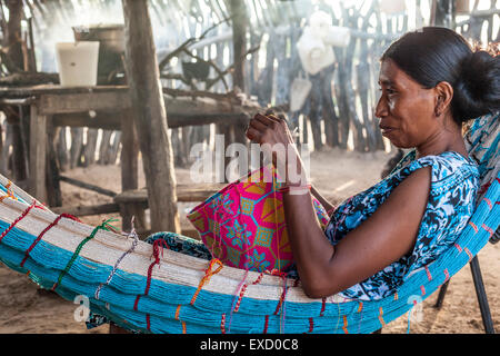 A young Wayuu indigenous woman knitting a "mochila", or traditional ...