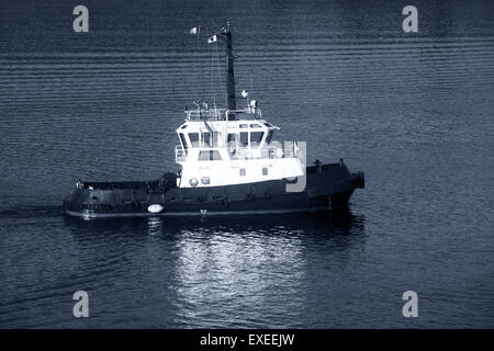 Tug boat with white superstructure underway, side view. Trondheim ...