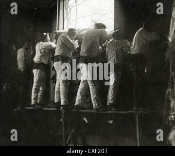 This historical image depicts soldiers involved in wiring parties ...