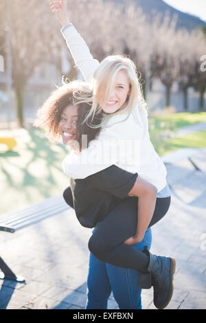Group of best friends giving a piggyback ride to his girlfriends ...