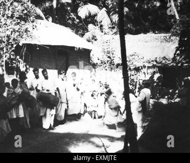 People waiting outside Mahatma Gandhi's hut to accompany him on his ...