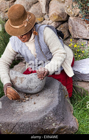 Older traditional Peruvian farm woman demonstrates how to plant ...