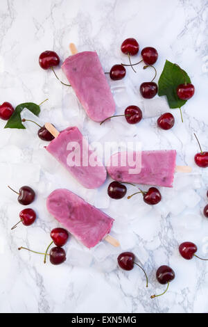 Cherry yoghurt ice lollies and cherries on white marble Stock Photo - Alamy