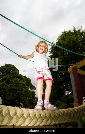 Girls play on rope climbing structure at outdoor park playground Stock ...