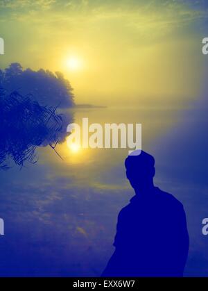 Man watching a sunrise over lake. Human silhouette. Photo with vintage ...