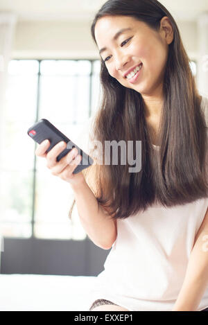 woman with smartphone sitting in bed at night Stock Photo - Alamy