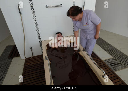 A man taking a ten minute crude oil bath offered as physical therapy in ...