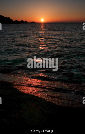 Sunset over Guernsey beach Stock Photo - Alamy