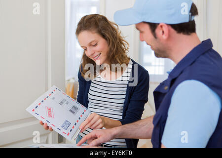 Man Handing a Letter to a Woman in the Entrance Hall of a House - by ...