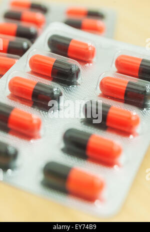 Selective focus of red and black capsule pills on stainless steel drug ...