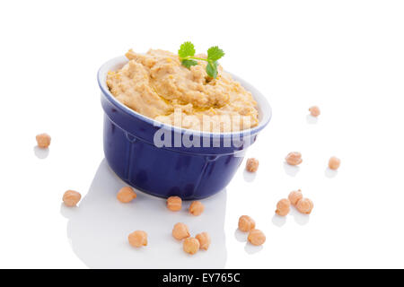 Delicious hummus in ceramic pot on white and blue table cloth isolated ...