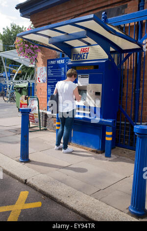 A young woman using a Fast Ticket machine at Warwick train station ...