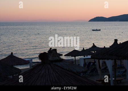 Sandy beach with umbrellas and sunbeds at sunset Stock Photo - Alamy
